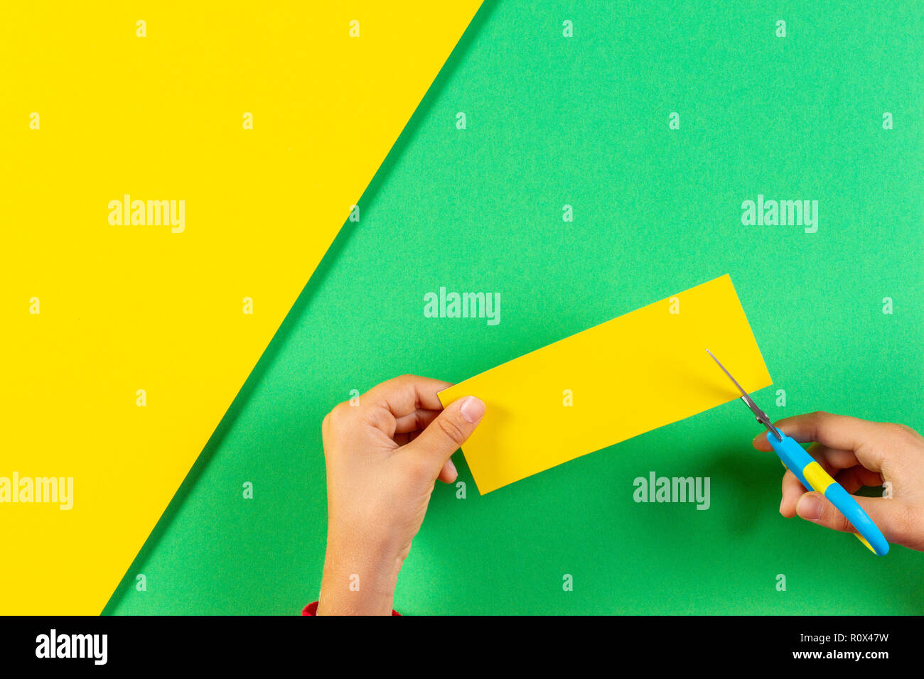 Kid's hands cutting blue color paper with scissors Stock Photo - Alamy