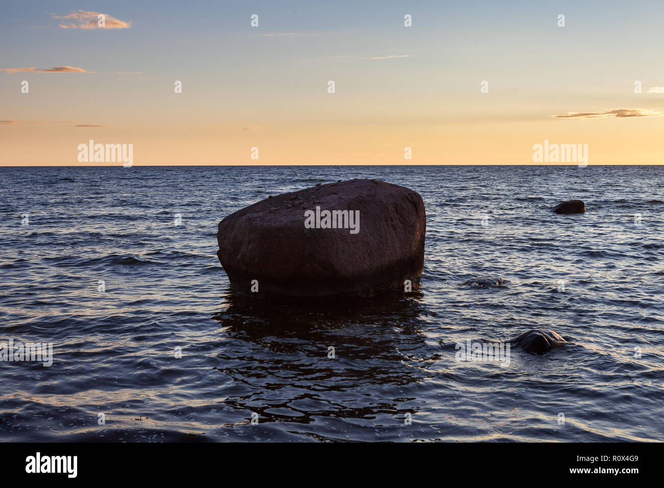 The boulder in the sea at sunset Stock Photo - Alamy