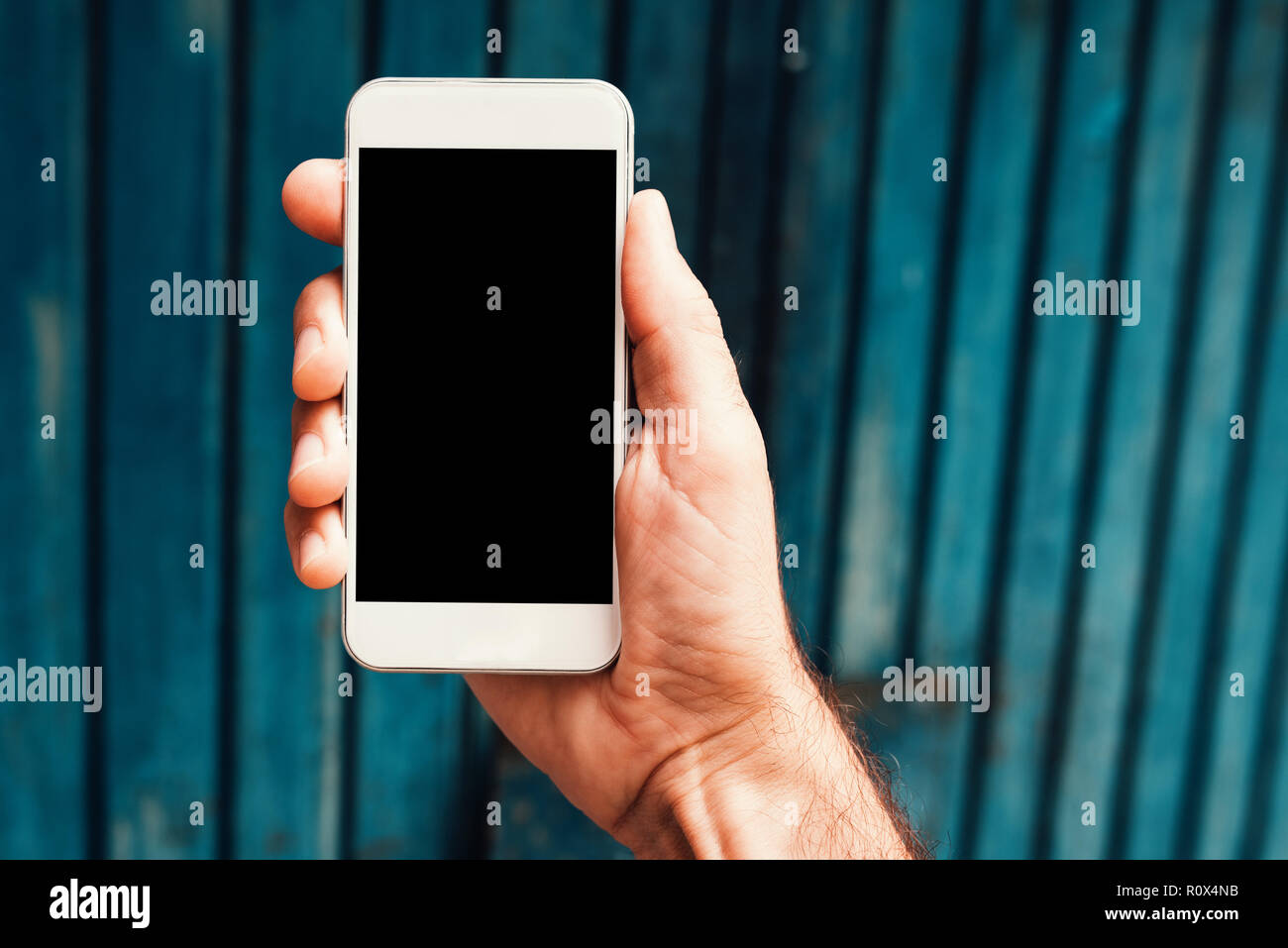Hand with smartphone mock up screen in urban surrounding. Man holding ...