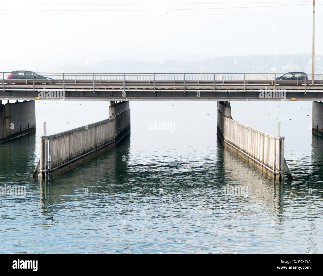 concrete bridge over water with a train line and road running parallel ...