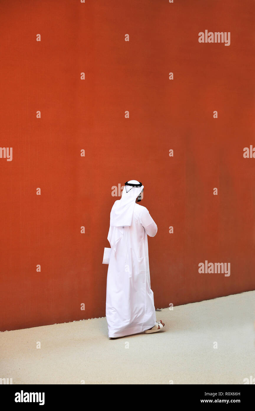 an elegant man of Arab ethnicity with sunglasses walks the streets of ...