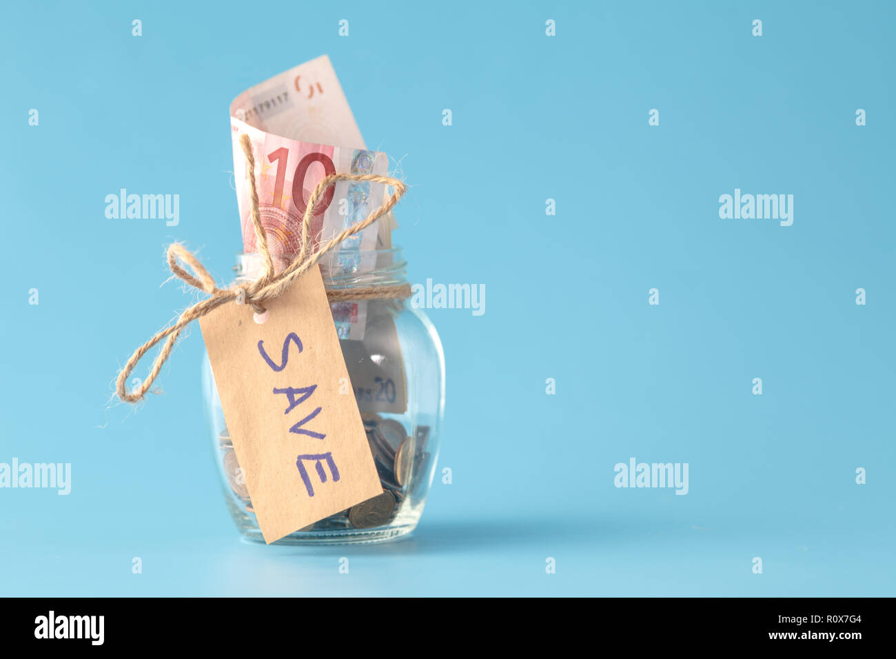 Coins in savings jar full of money Stock Photo - Alamy