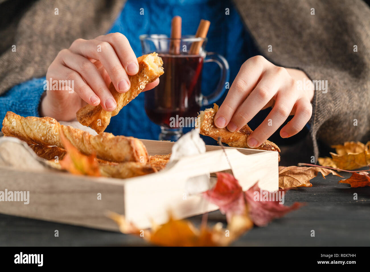 Girl in plaid eat sweep cokies, seasoning fall leaves around Stock ...