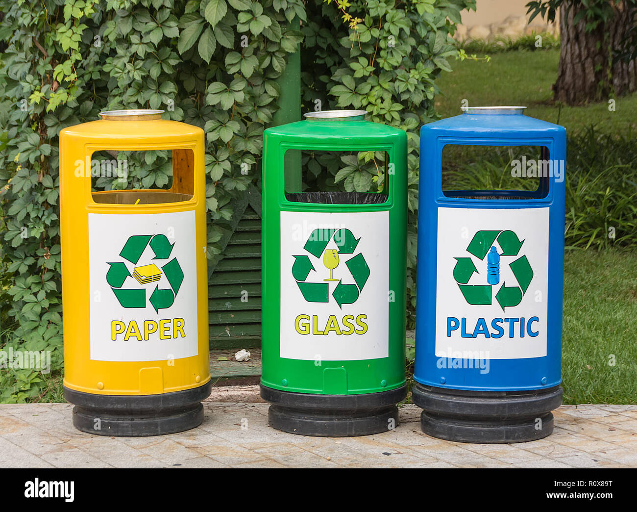 Three multicolored recycle bins for waste with icons for the ... Three multicolored recycle bins for waste with icons for the ...