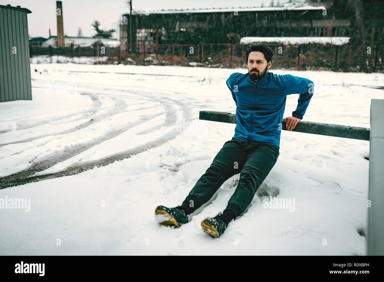 Active young man stretching and doing exercises in the public place ...