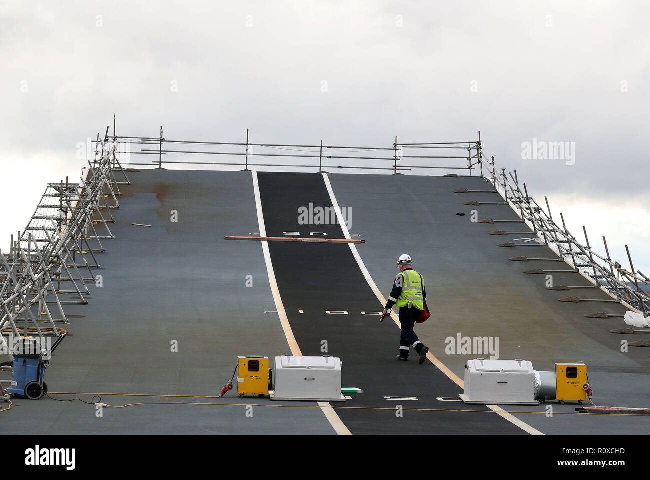 A workman walks across the ramp area of the flight deck during a tour ...