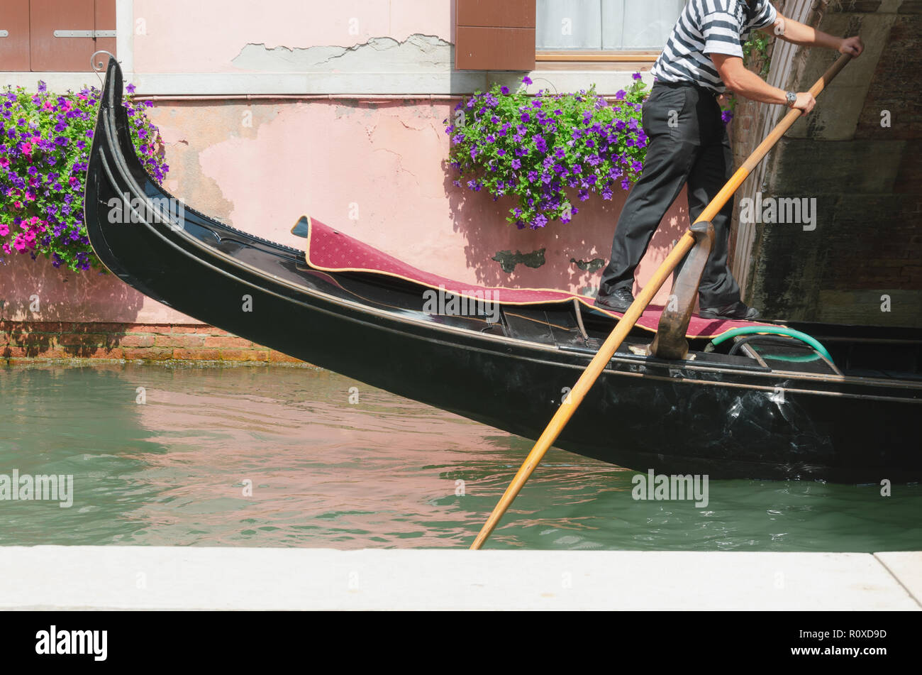 Venice canal, channel and gondolier rowing under the little bridge ...