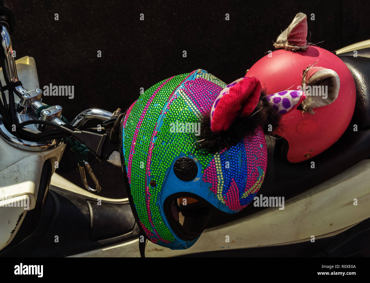 two colorful helmets on a motorbike Stock Photo - Alamy