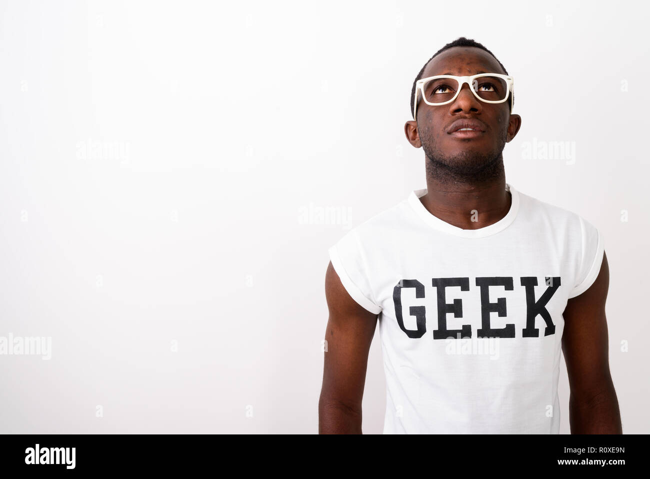 Studio shot of young black African nerd man thinking and looking Stock ...