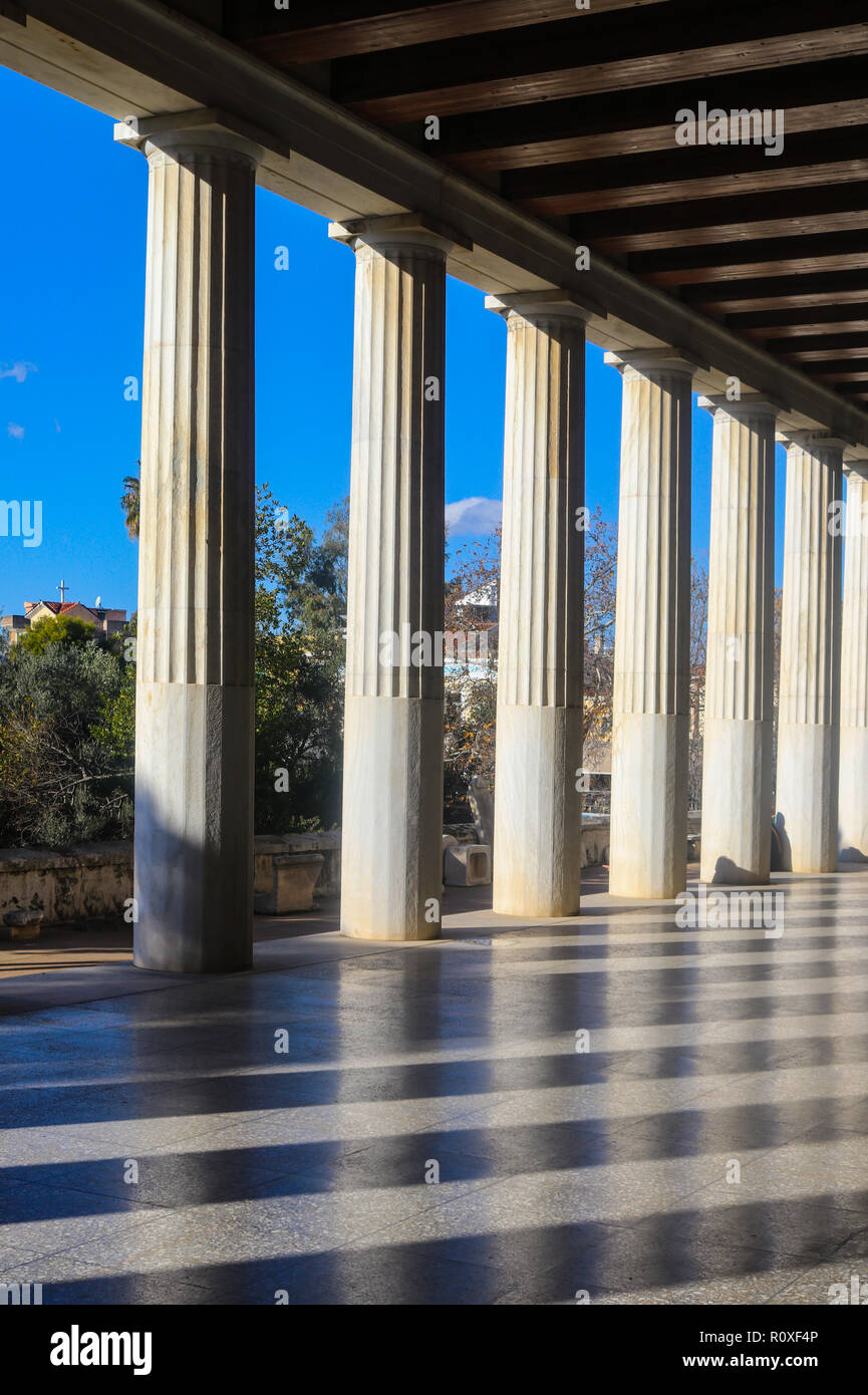 Columns cast shadows across the marble floor of the covered walkway at ...