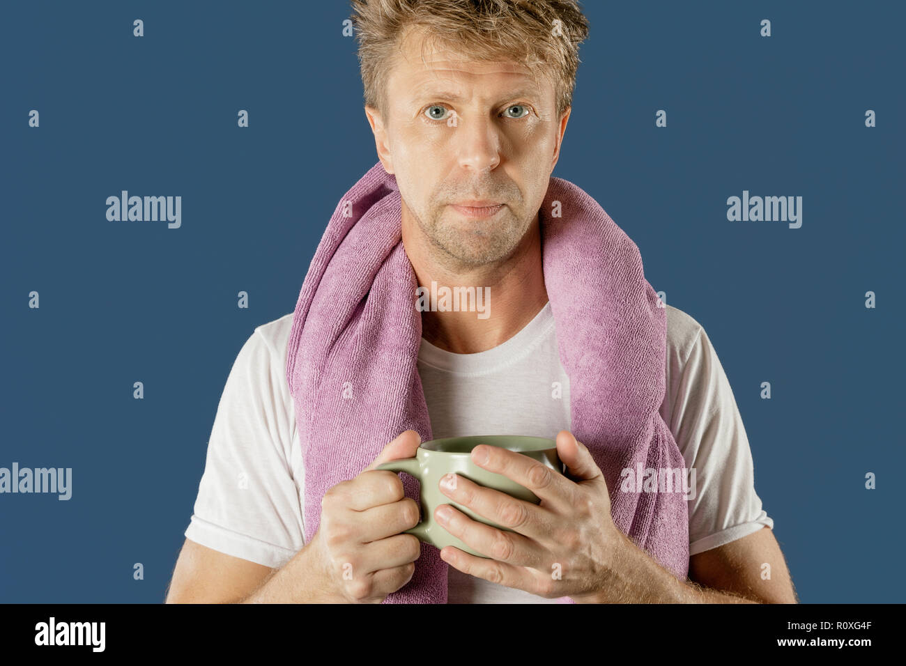 Sleepy man with a mug of coffee and a towel Stock Photo - Alamy