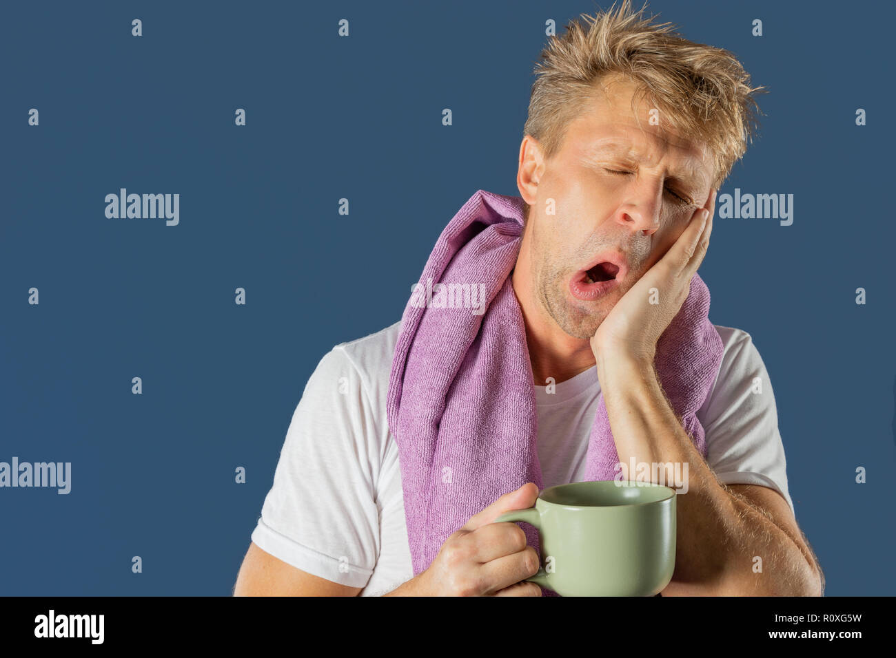 Sleepy man with a mug of coffee and a towel Stock Photo - Alamy