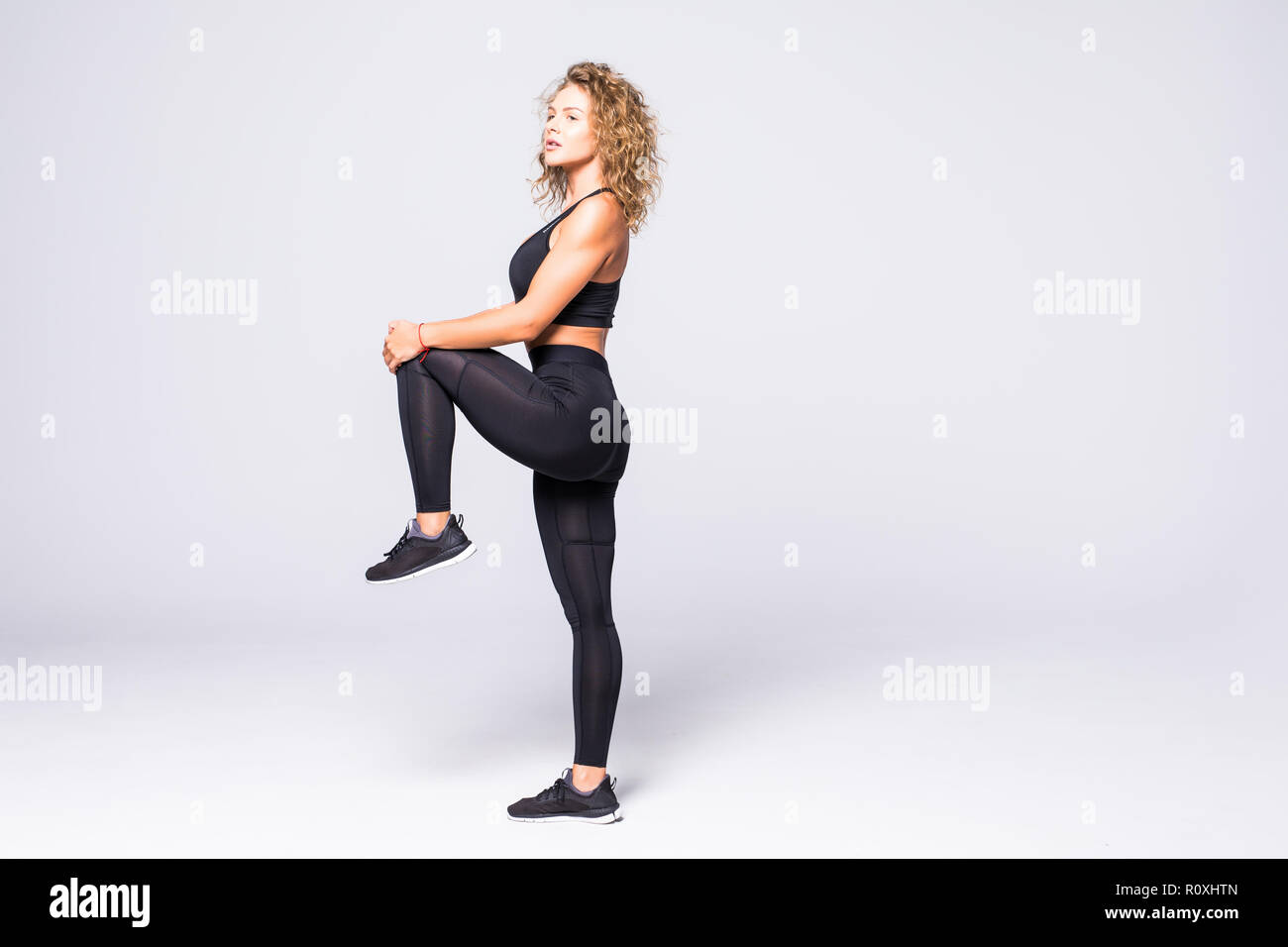 Side view of a sporty young woman jumping isolated on white background ...