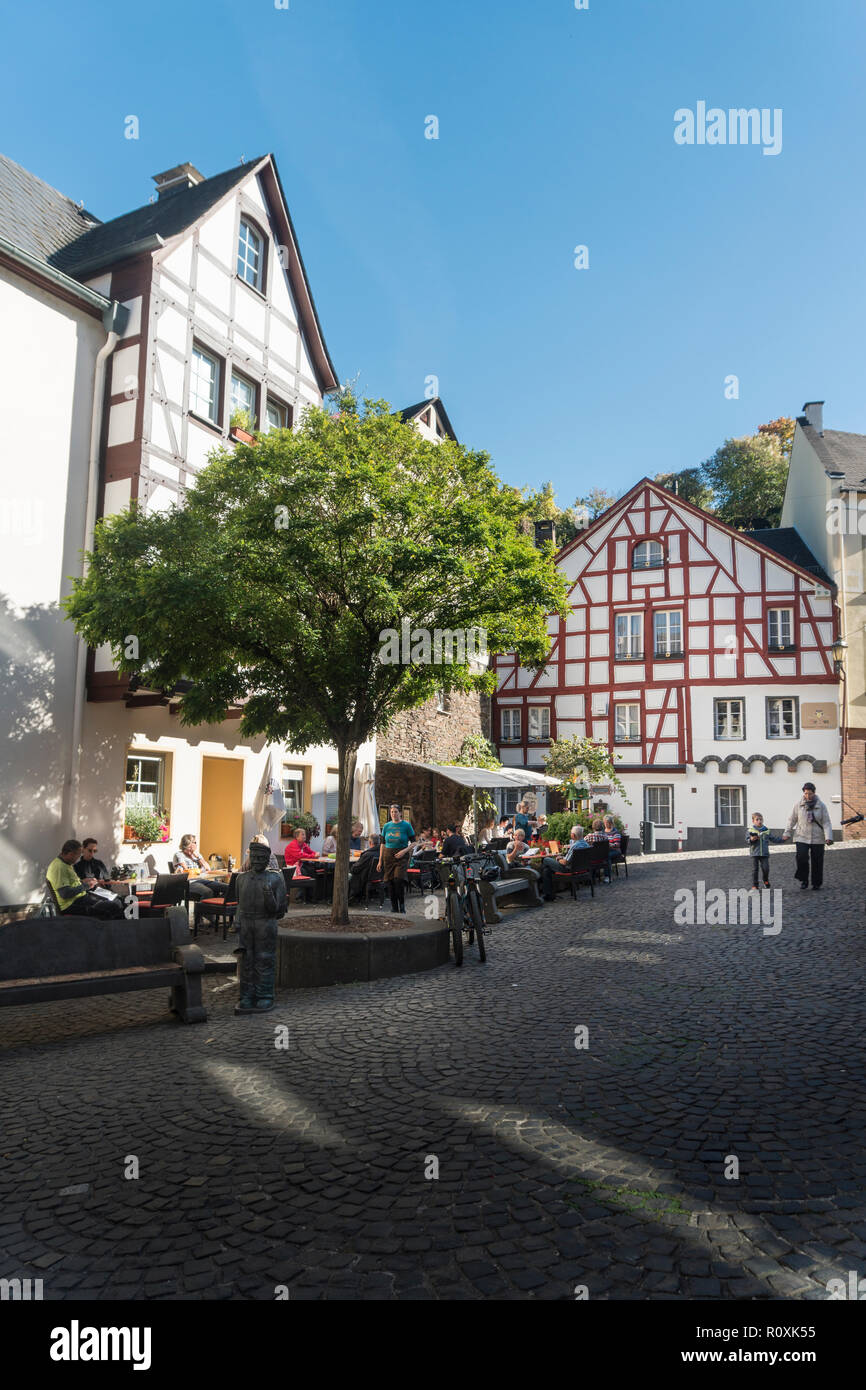 A busy town square in the city of Cochem, Germany with people sitting ...