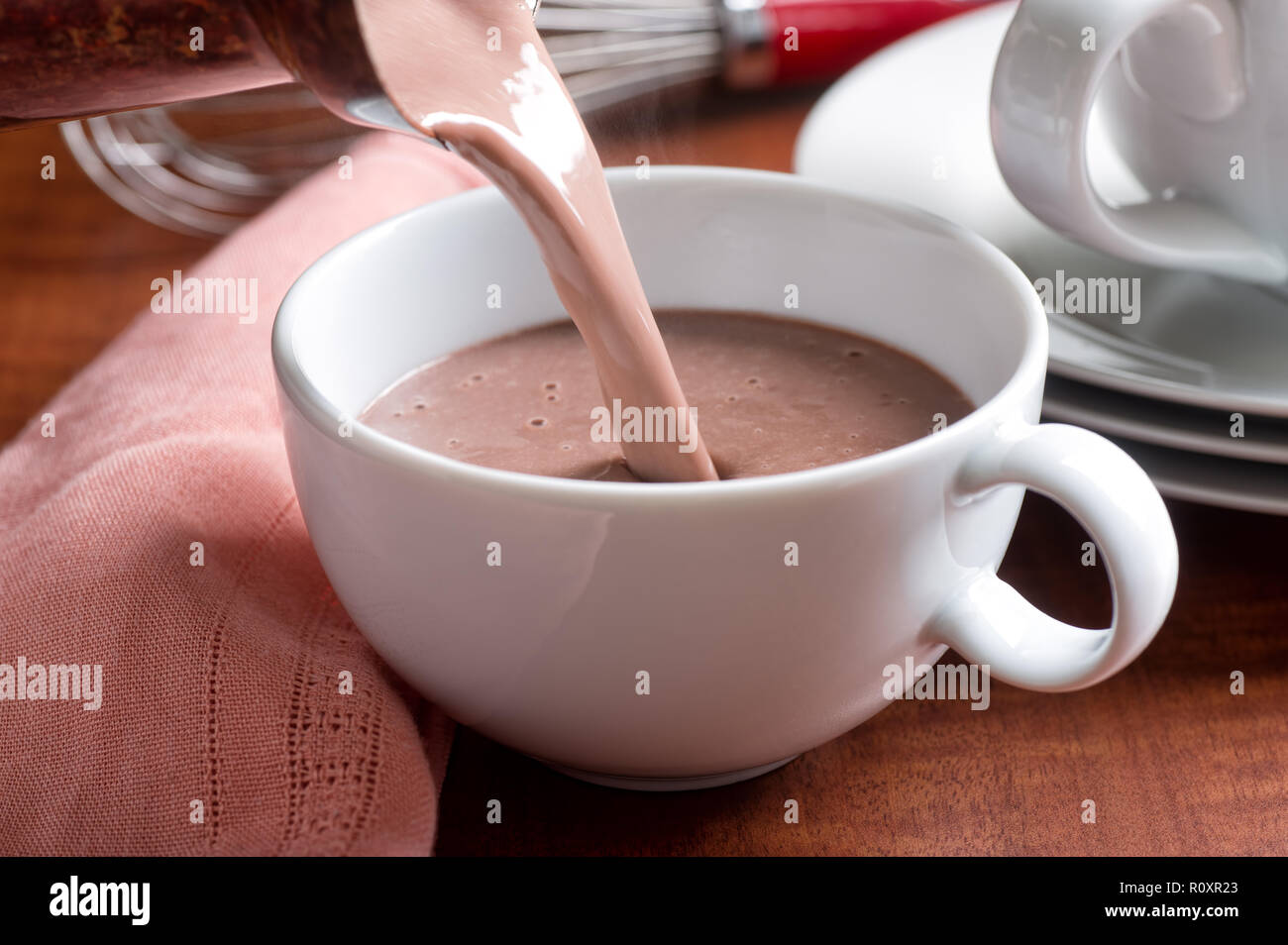 Pouring a cup of freshly made hot chocolate Stock Photo - Alamy