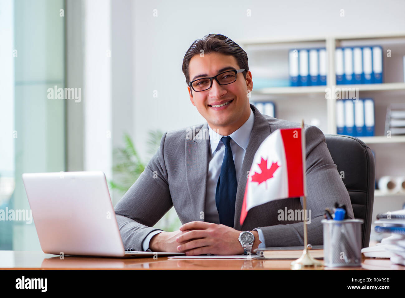 Businessman with Canadian flag in office Stock Photo - Alamy