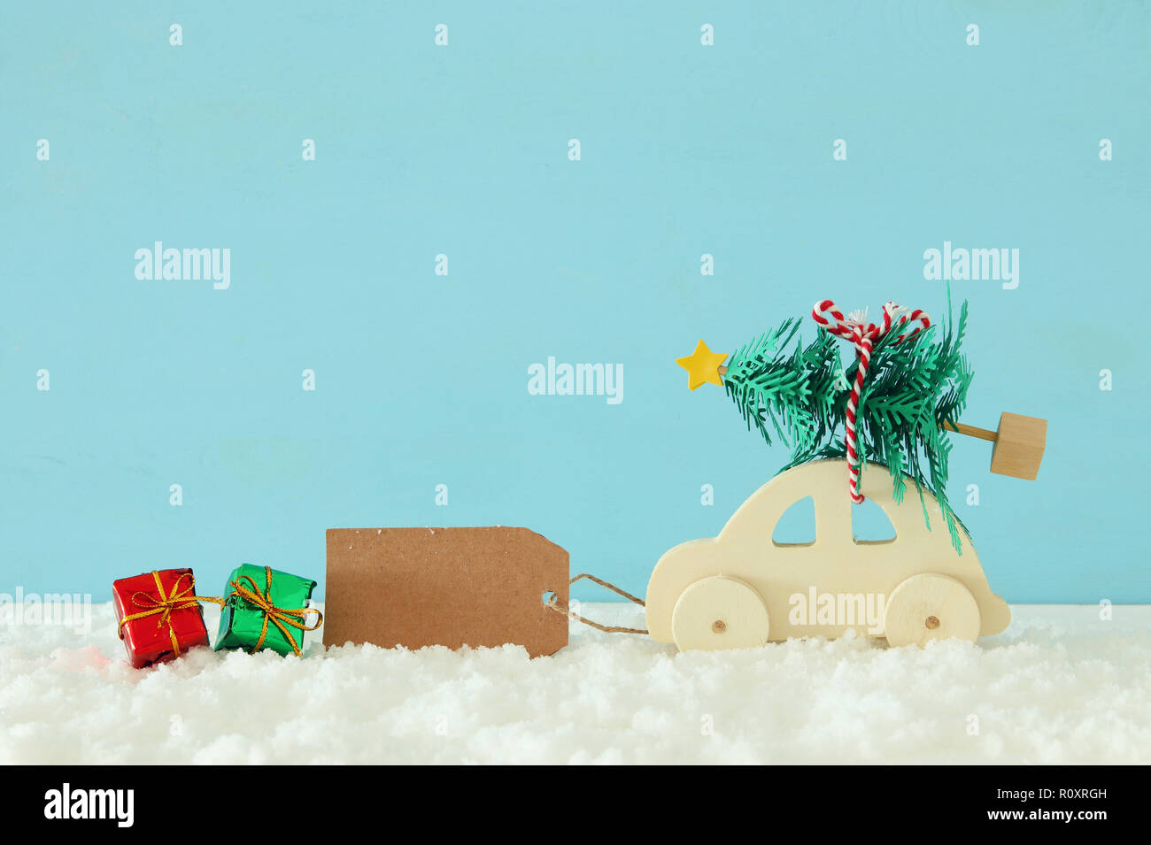 Wooden car carrying a christmas tree in front of blue background Stock ...