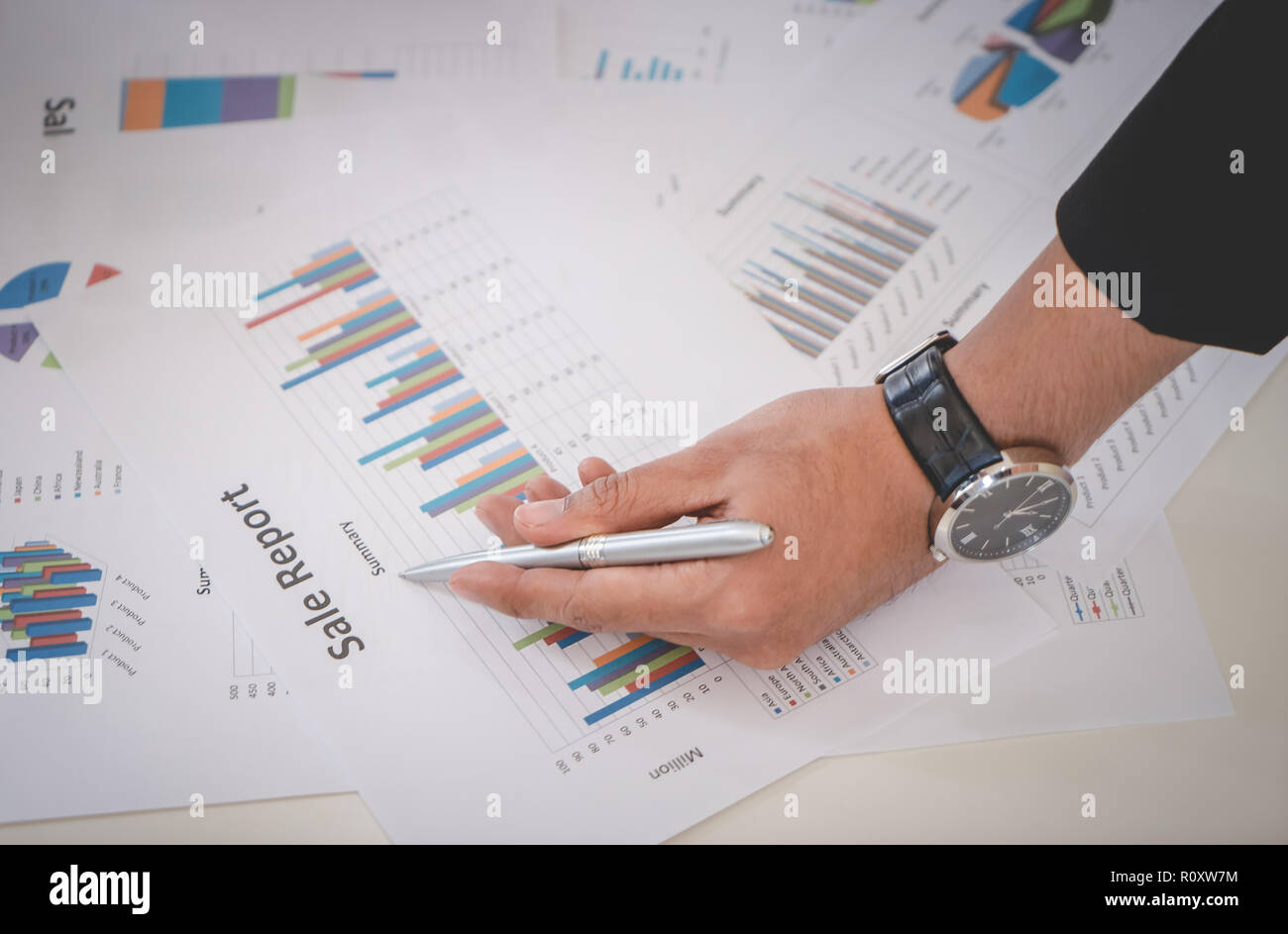 Business man marking on data sheet using metal pen Stock Photo - Alamy