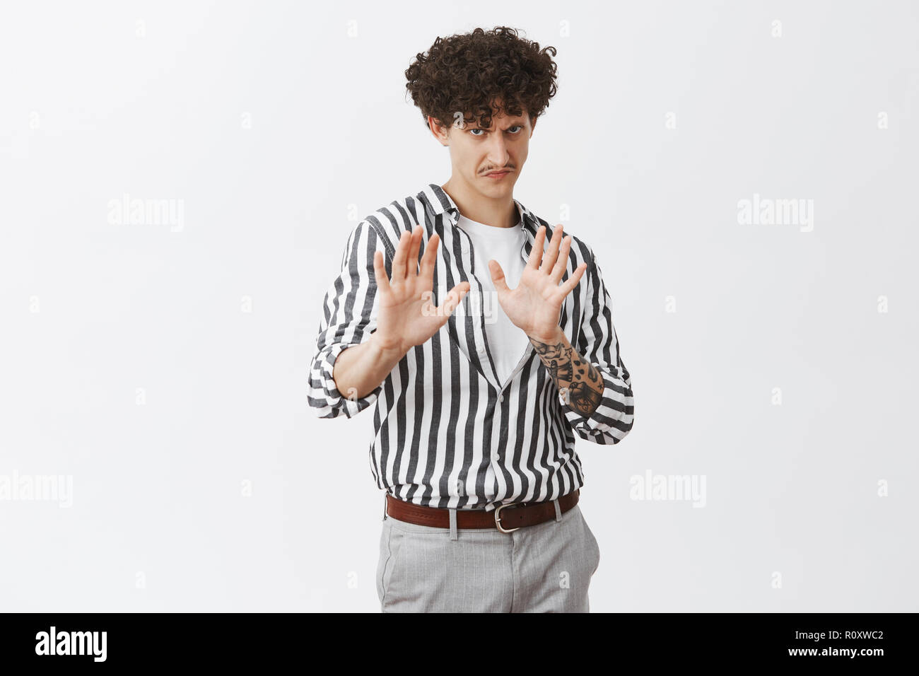 Gloomy arrogant and displeased mad guy with dark curly hair and ...