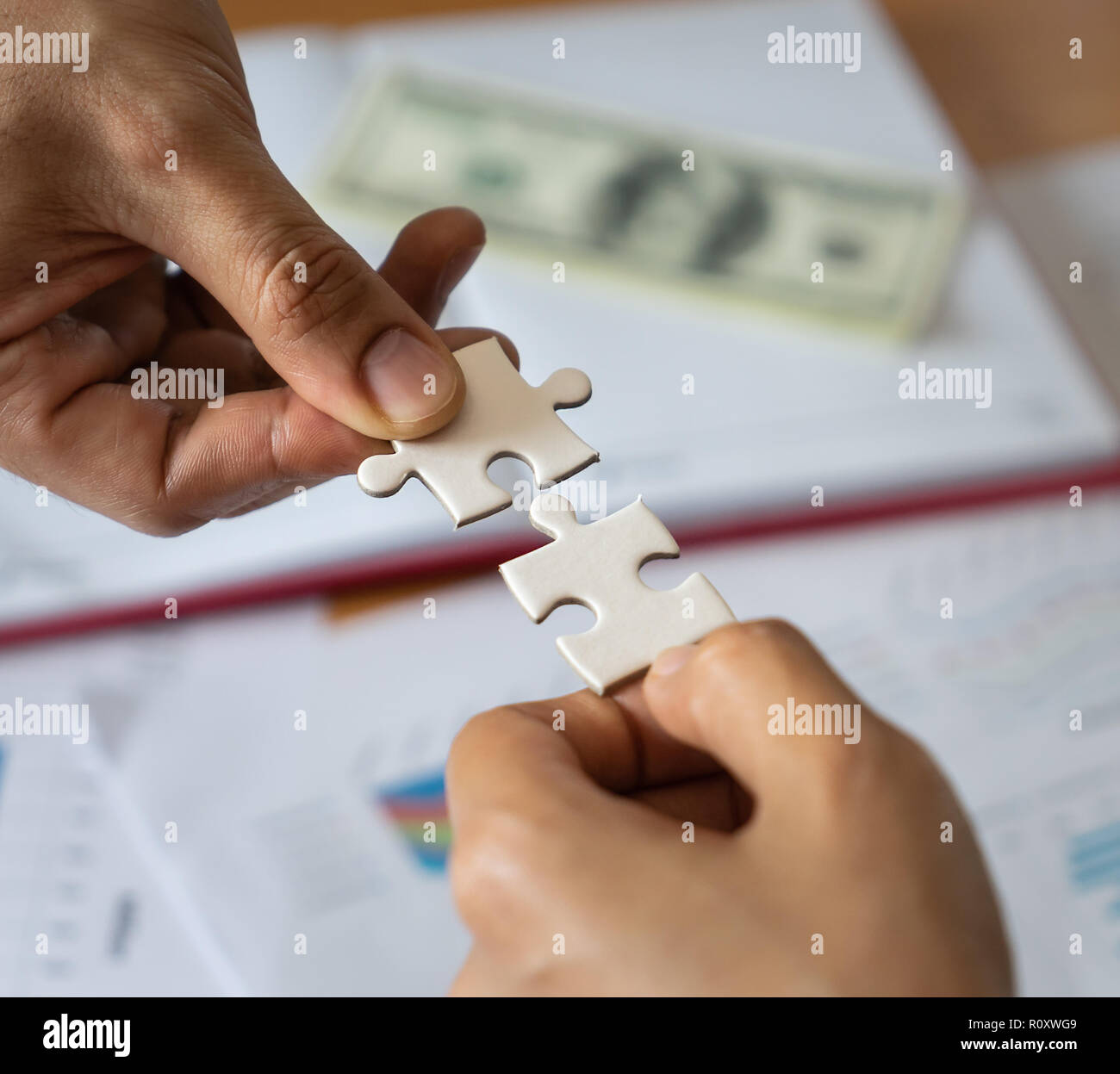 Two hands joining together two jigsaw puzzles Stock Photo - Alamy