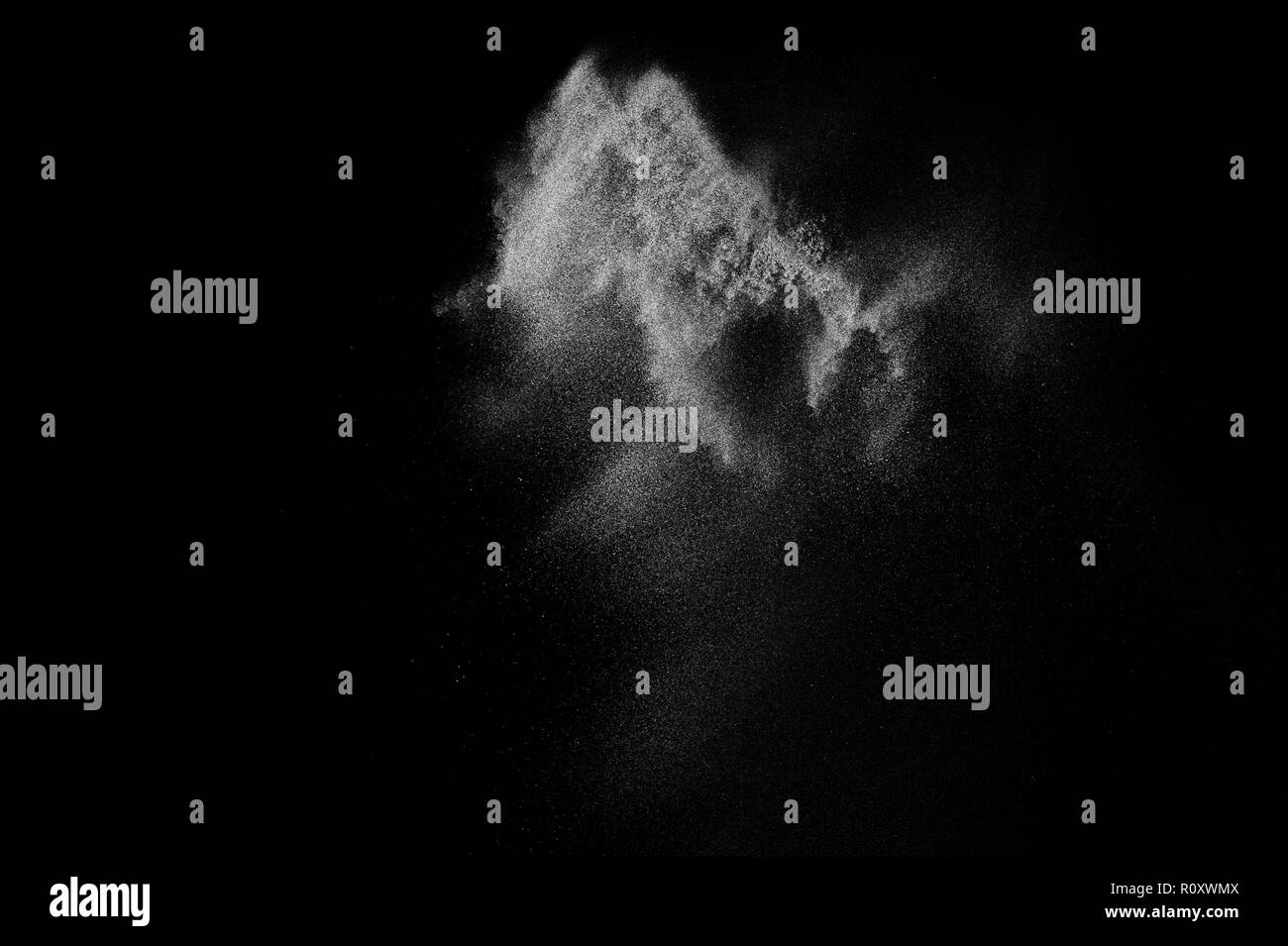 Freeze motion of white particles on black background. Powder explosion ...