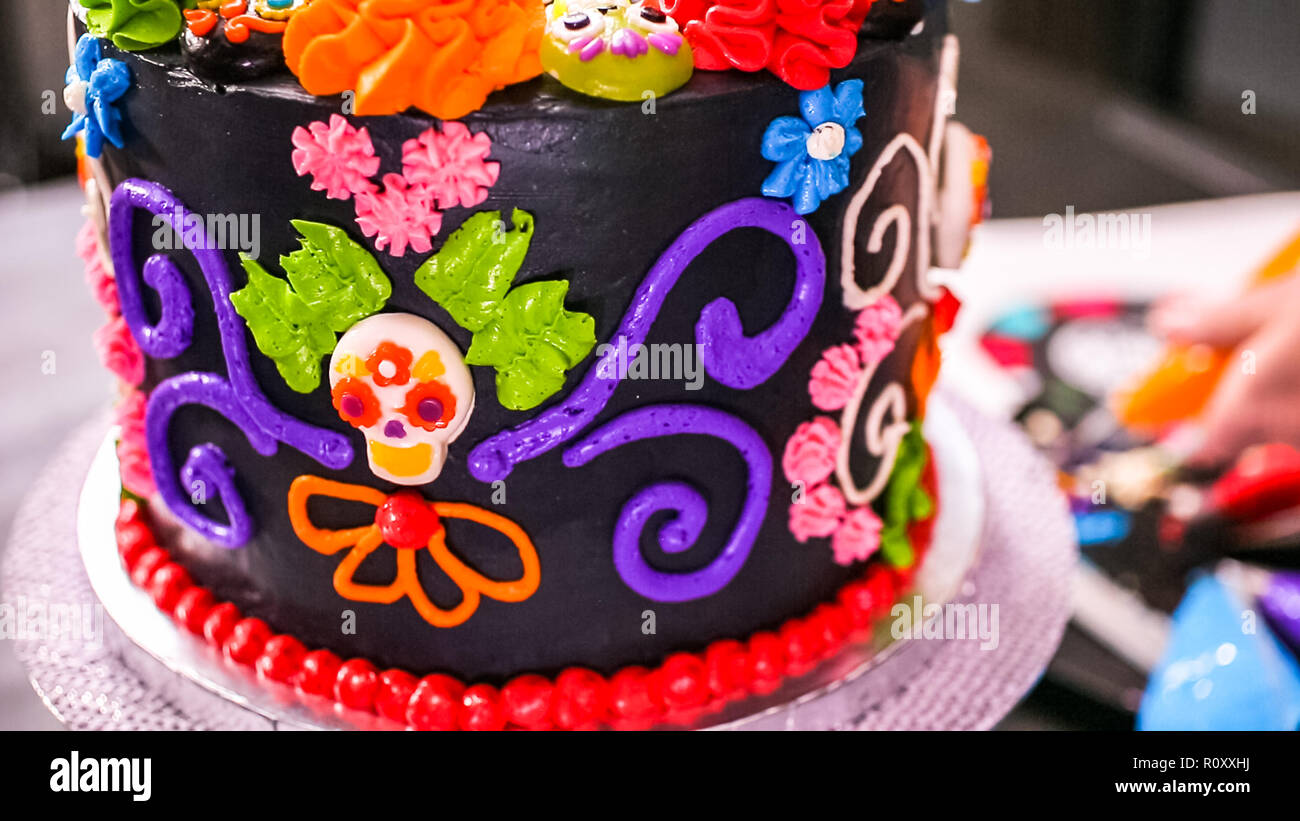 Step by step. Baker decorating multilayer chocolate cake with colorful ...