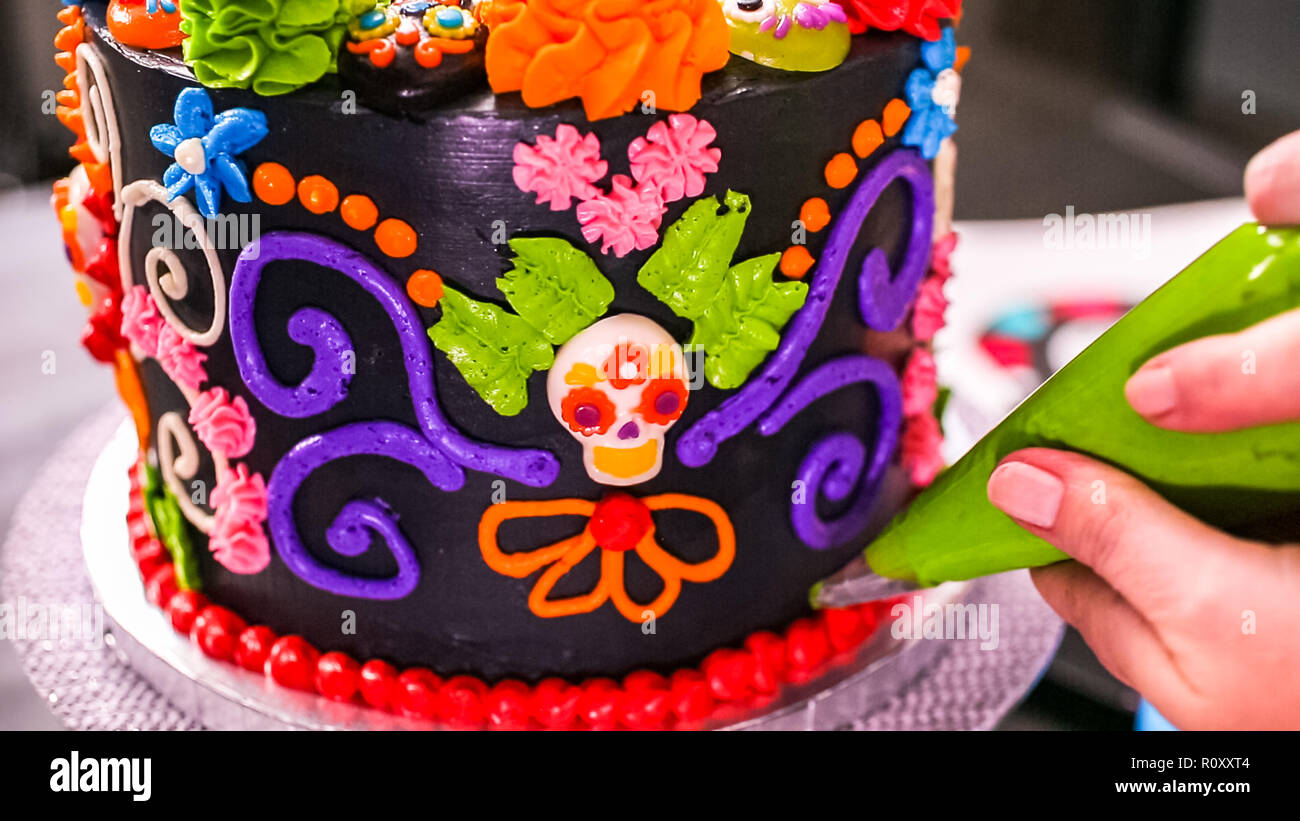 Step by step. Baker decorating multilayer chocolate cake with colorful ...