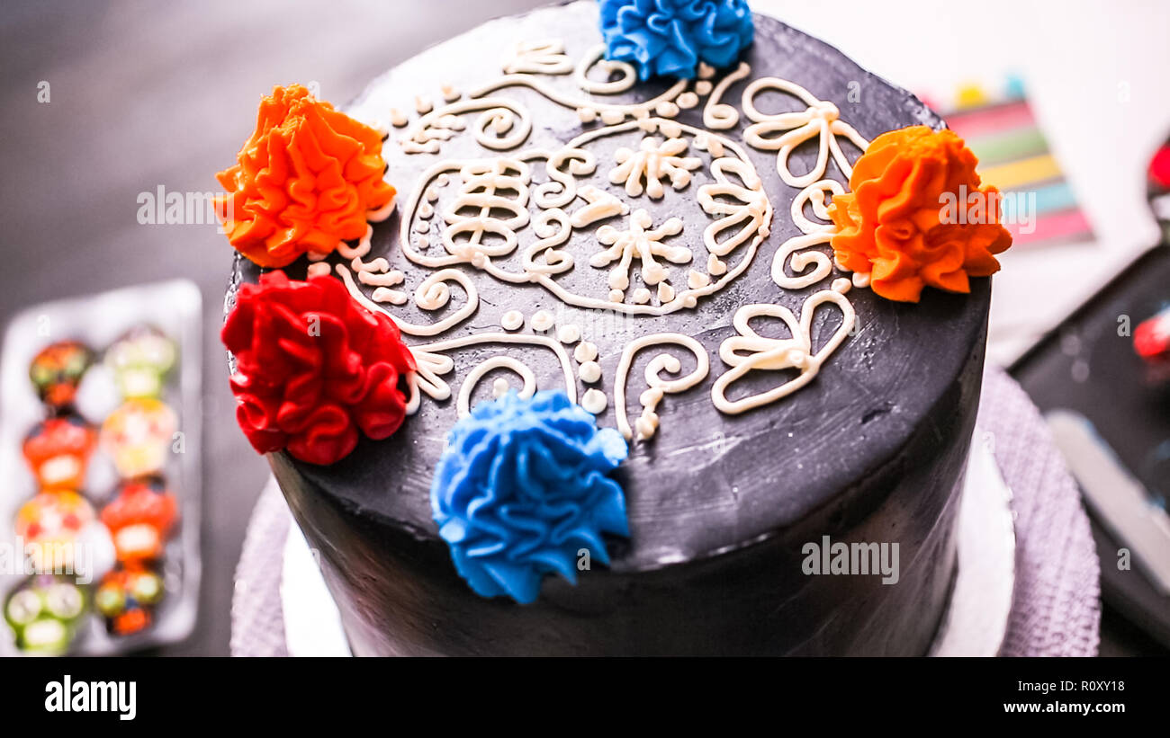 Step by step. Baker piping colorful buttercreal italian icing on a top ...