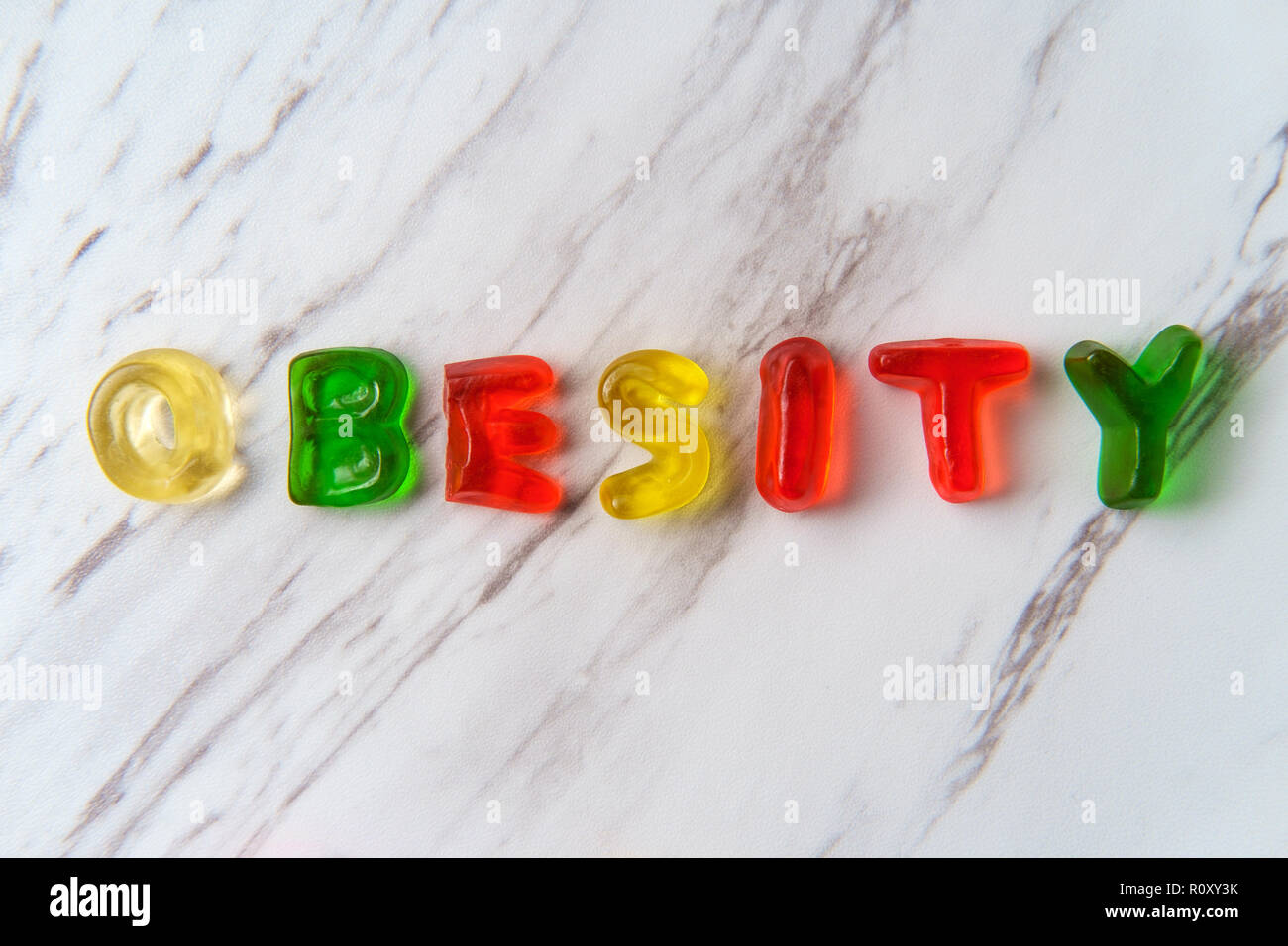 Assorted colorful gummy candy letters spell the word Obesity Stock ...