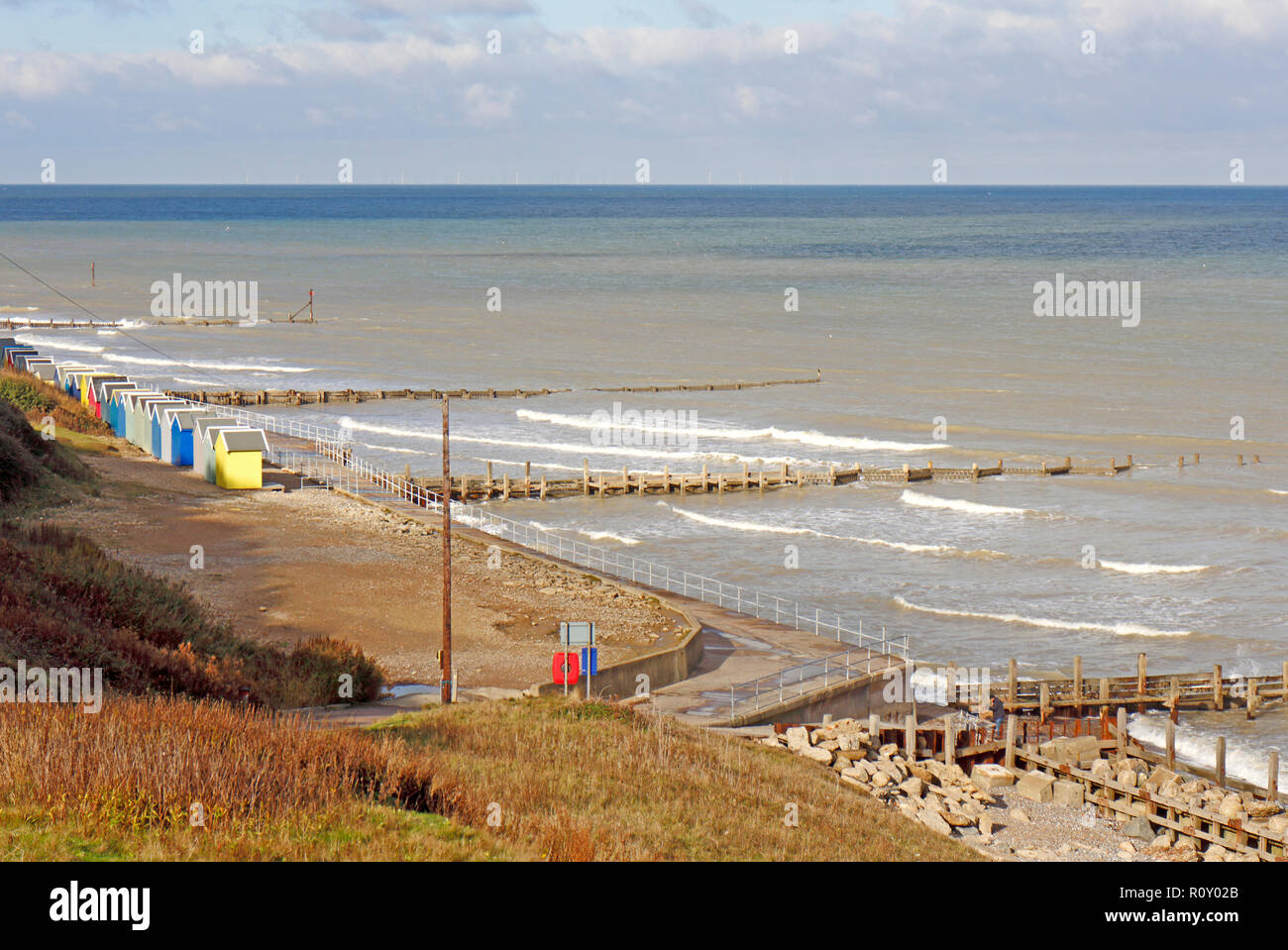 A view of the sea, promenade, and beach huts, in North Norfolk at the ...