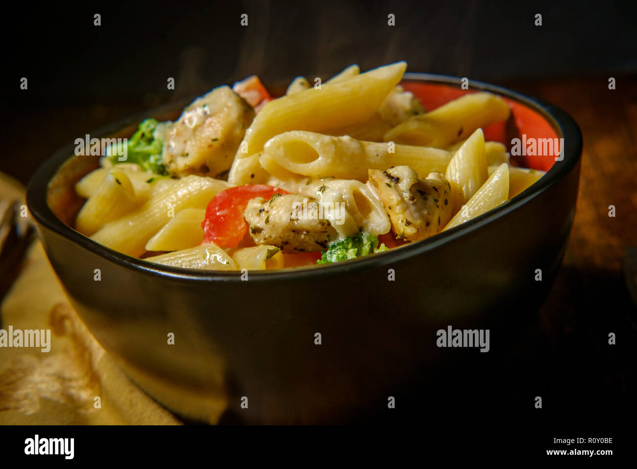 Grilled chicken alfredo penne primavera with dark moody lighting on ...