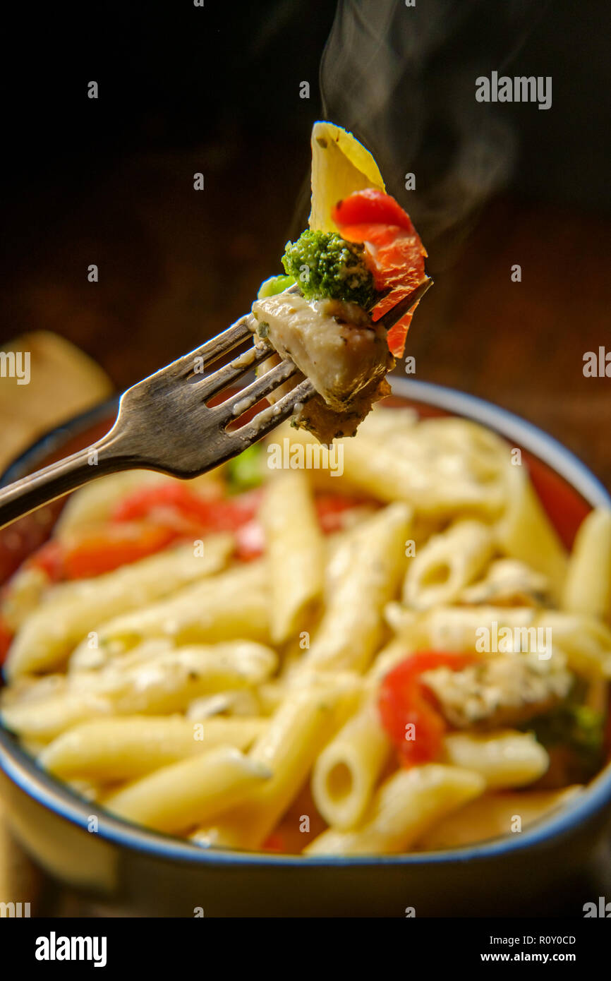 Grilled chicken alfredo penne primavera with dark moody lighting on ...