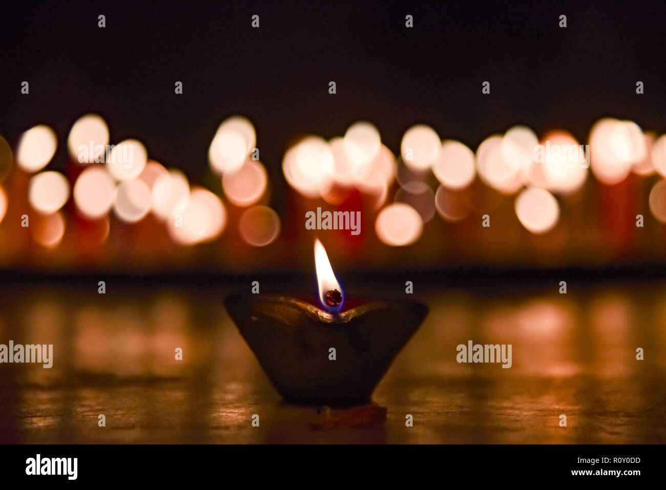 A diya (earthen lamp) seen lighted up inside a temple in the outskirts ...