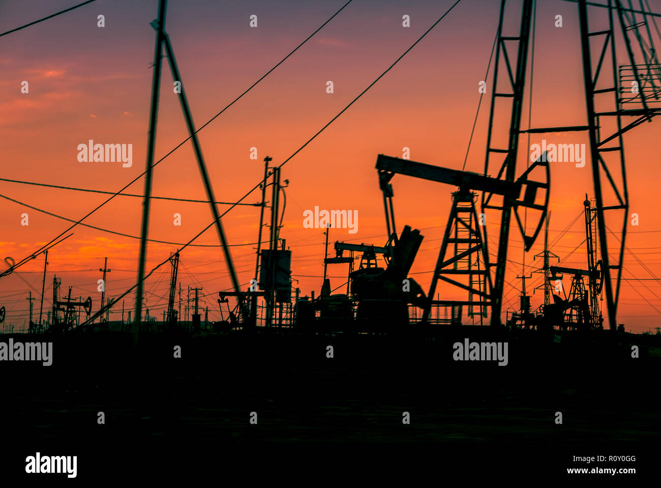 Energy extraction, crude oil recovery industry at sunset, blurred ...
