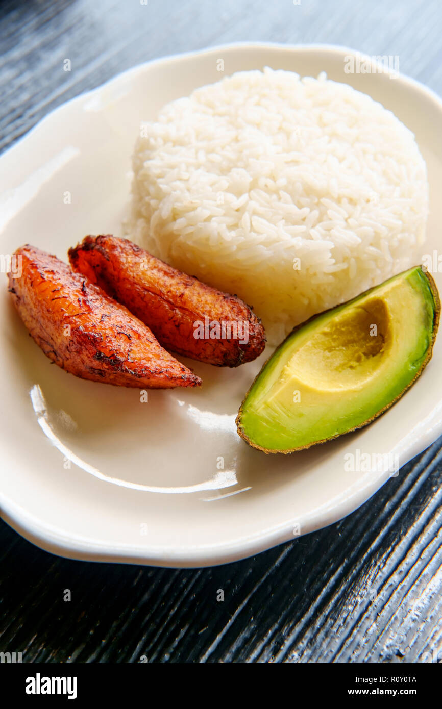 Side of Colombian fried plantains white rice and avocado Stock Photo ...