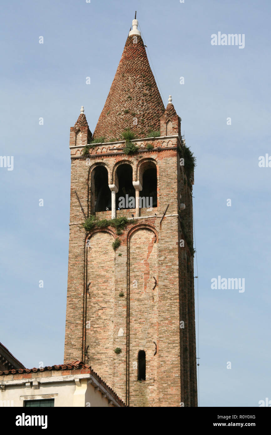 Venice, brick bell tower with cone roof and weeds on the walls Stock ...