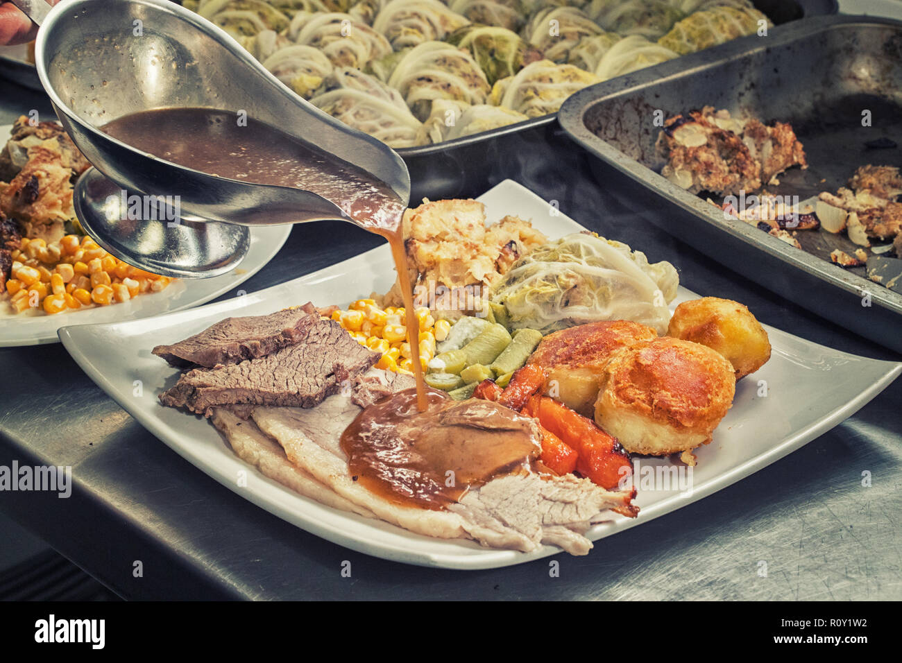 Sunday roast beef and pork dinner with roast potatoes, beans, sweetcorn ...