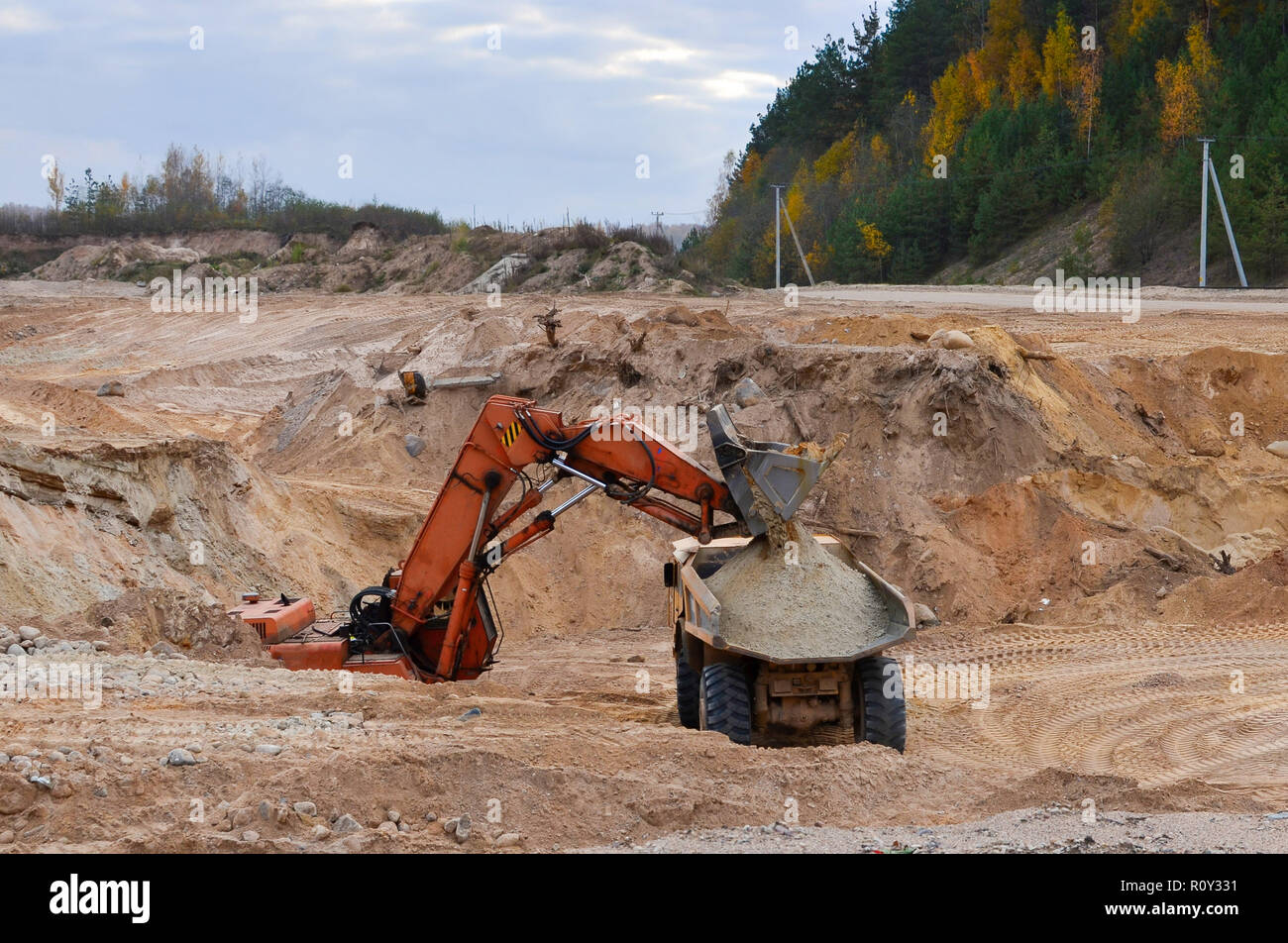 Excavator loading sand into dumper truck. Quarry for the extraction of ...