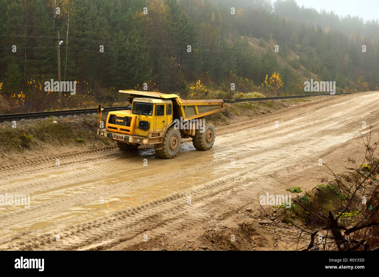Big yellow diesel quarry dumper at work. Heavy mining truck ...