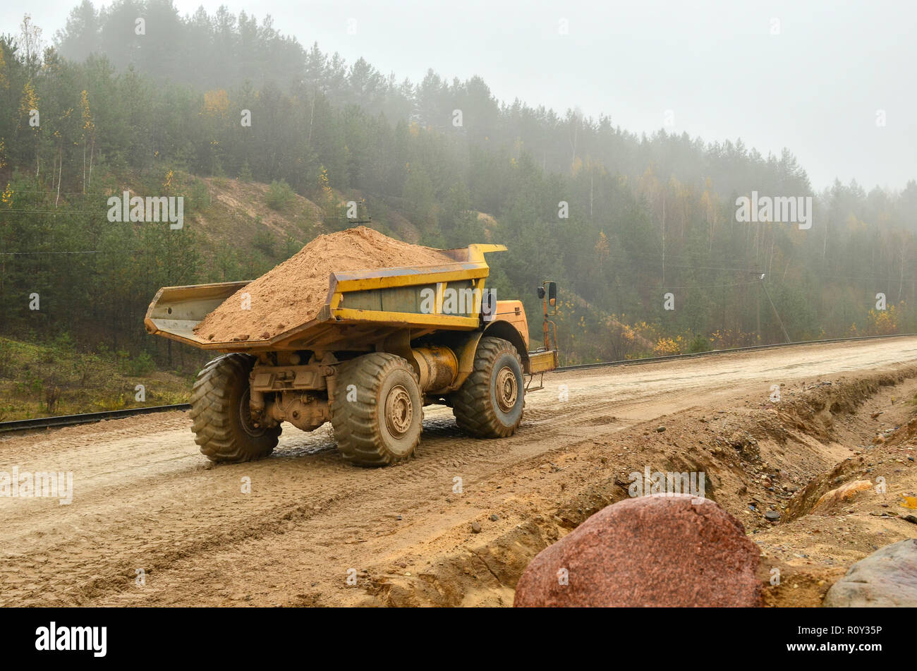 Big yellow diesel quarry dumper at work. Heavy mining truck ...