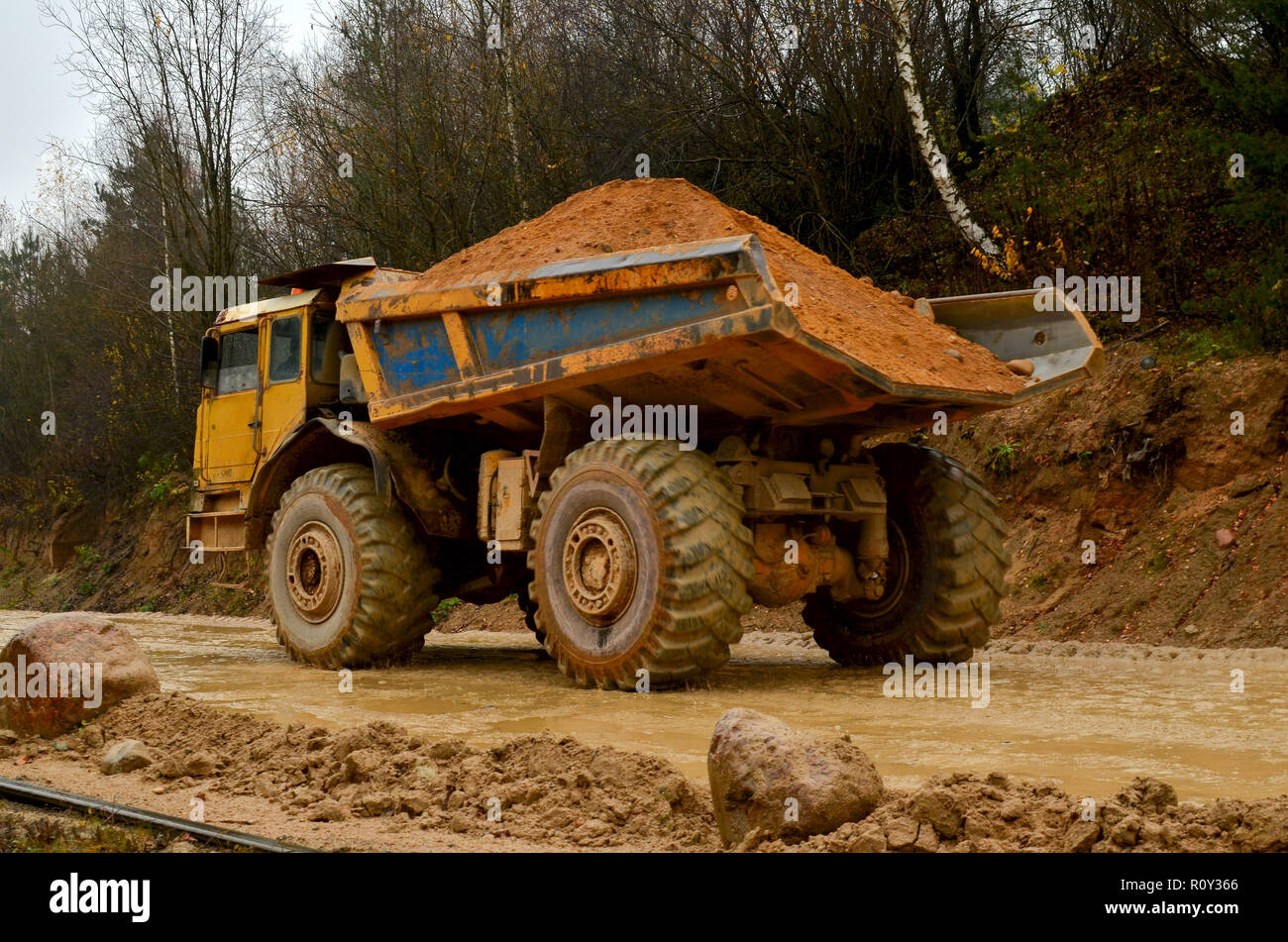 Big yellow diesel truck working in a mining quarry. Heavy mining truck ...