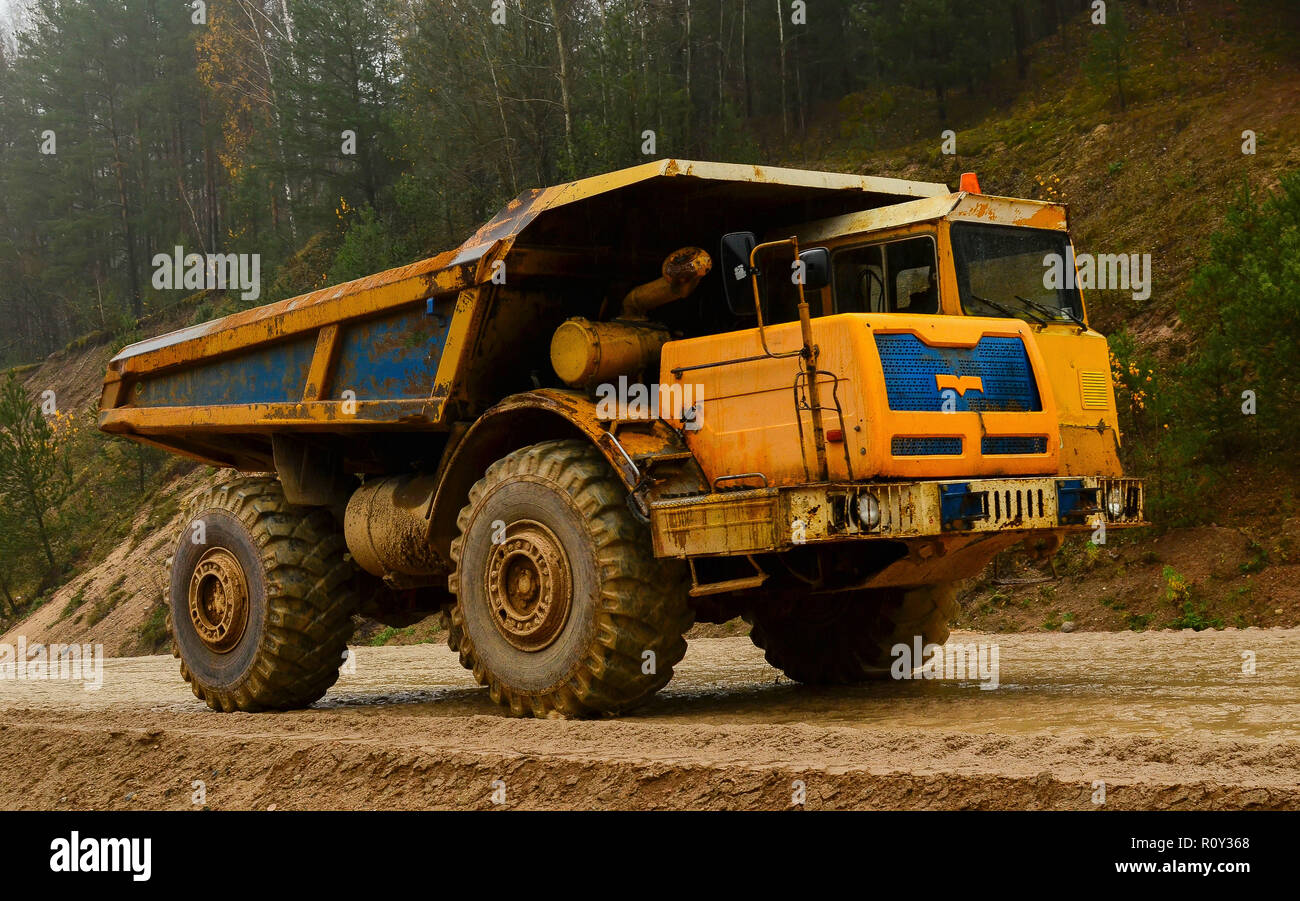 Big yellow diesel quarry dumper at work. Heavy mining truck ...
