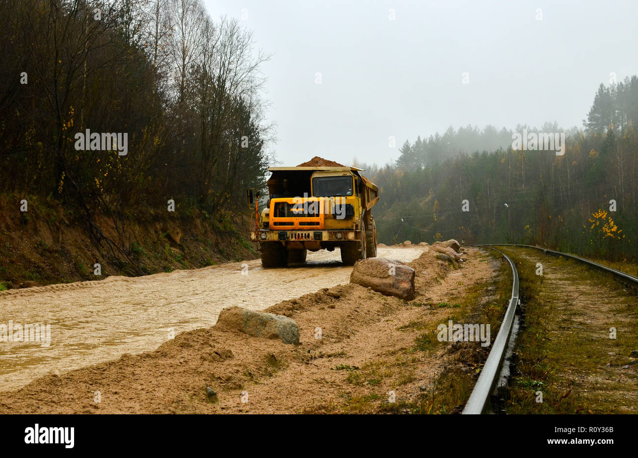 Big yellow diesel quarry dumper at work. Heavy mining truck ...