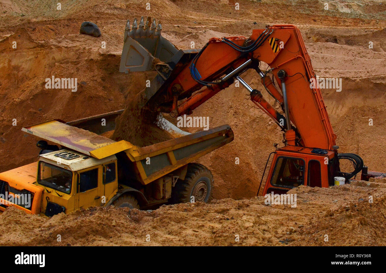 Excavator loading sand into dumper truck. Quarry for the extraction of ...