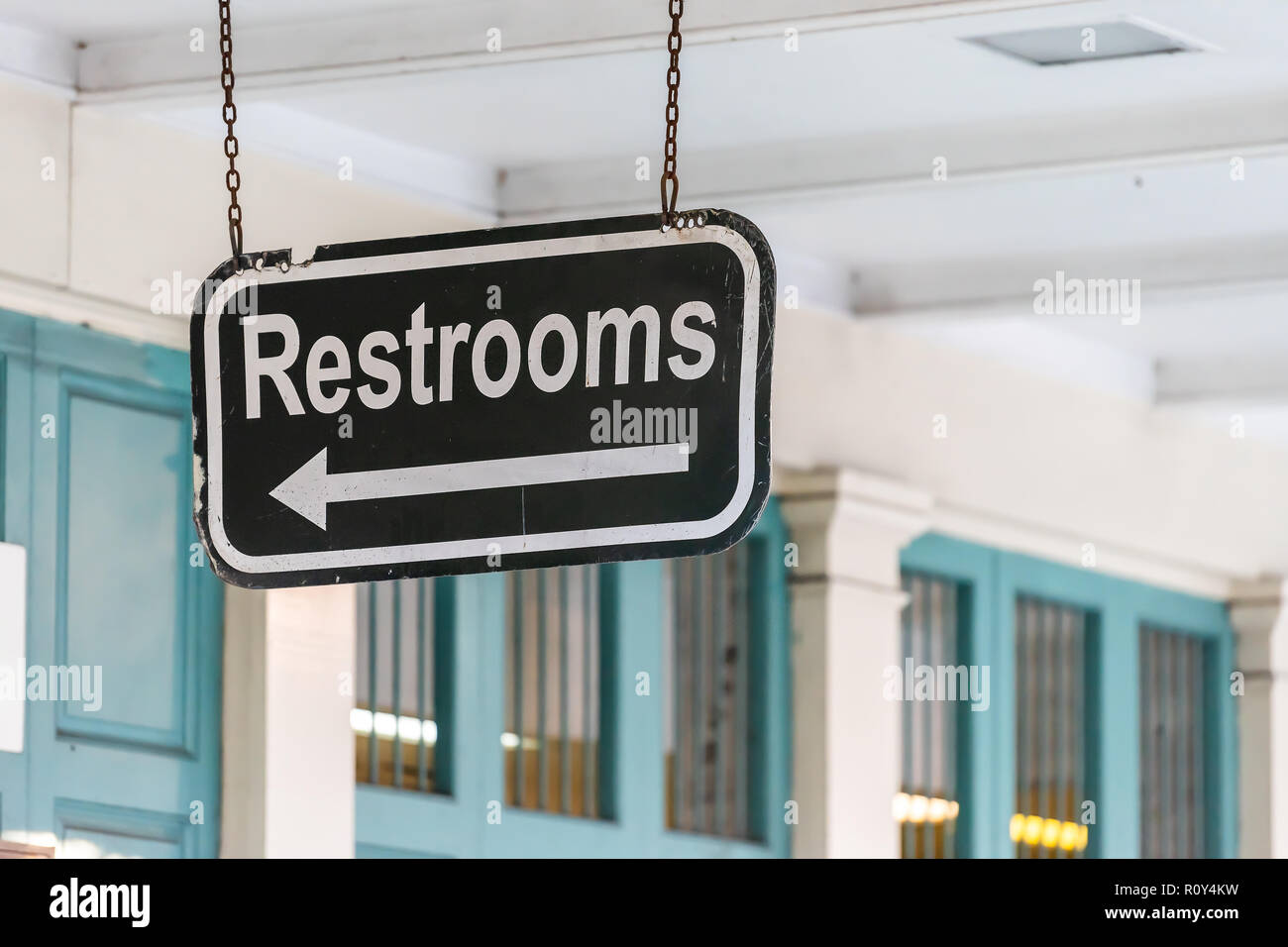Restrooms bathroom old black and white sign on building hanging on ...