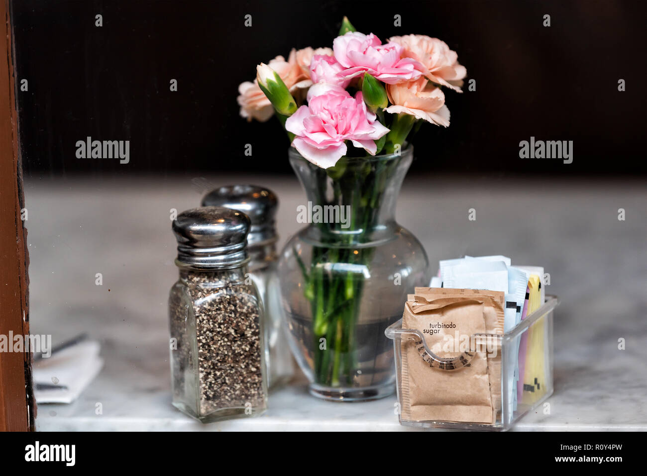 Closeup of salt, pepper and brown raw turbinado sugar shakers, packets ...
