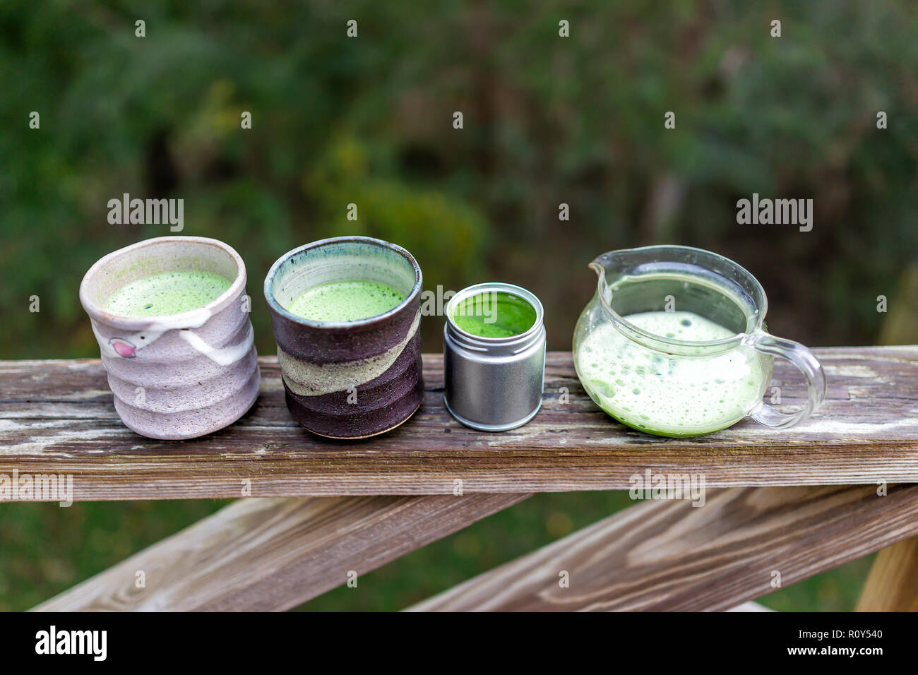 Glass teapot on wooden railing outside on backyard deck garden, two ...