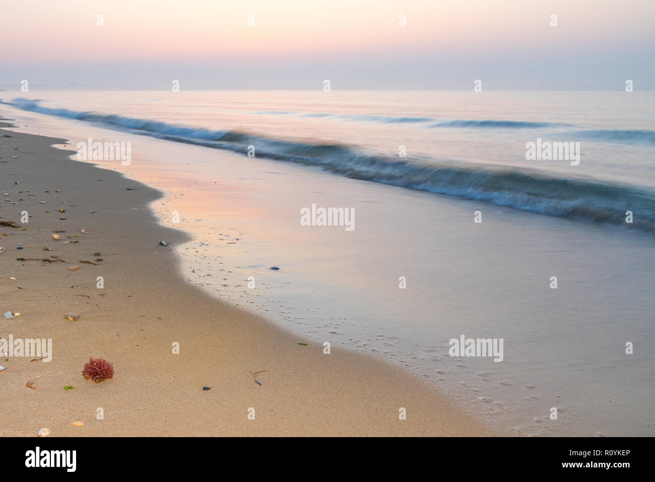 Beautiful sunrise reflections on beach Stock Photo - Alamy