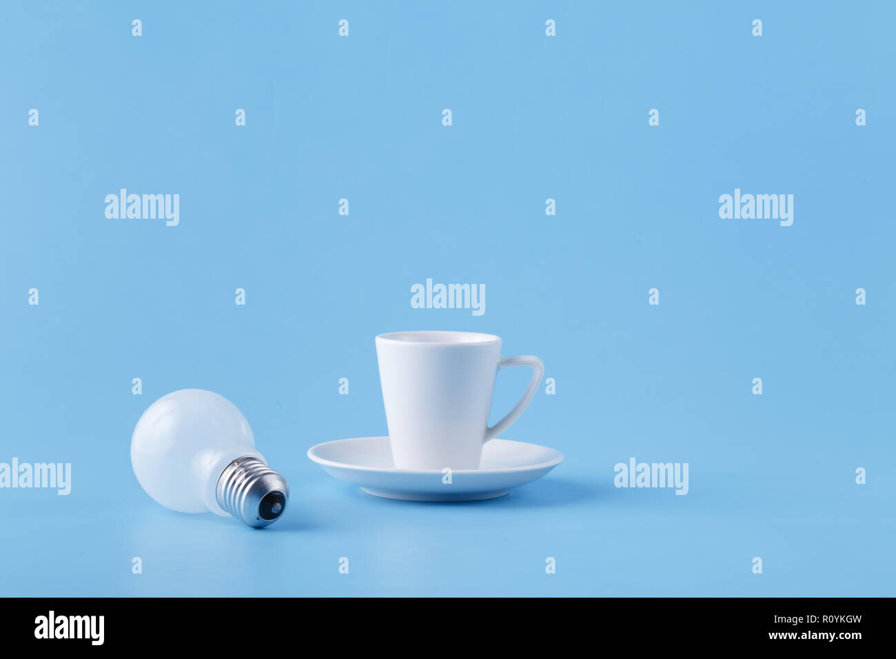Energy for long day, coffee cup on blue with light bulb Stock Photo - Alamy