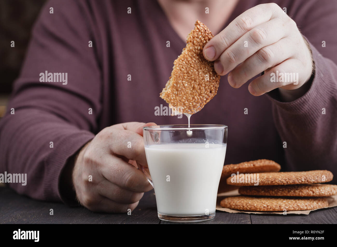 Dunking cookies in glass of milk Stock Photo - Alamy